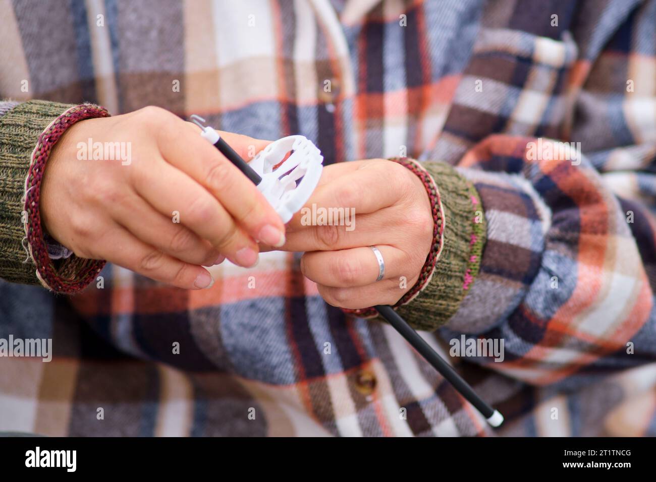 The closeup shot shows a hand spinning thread on a vintage spinning ...