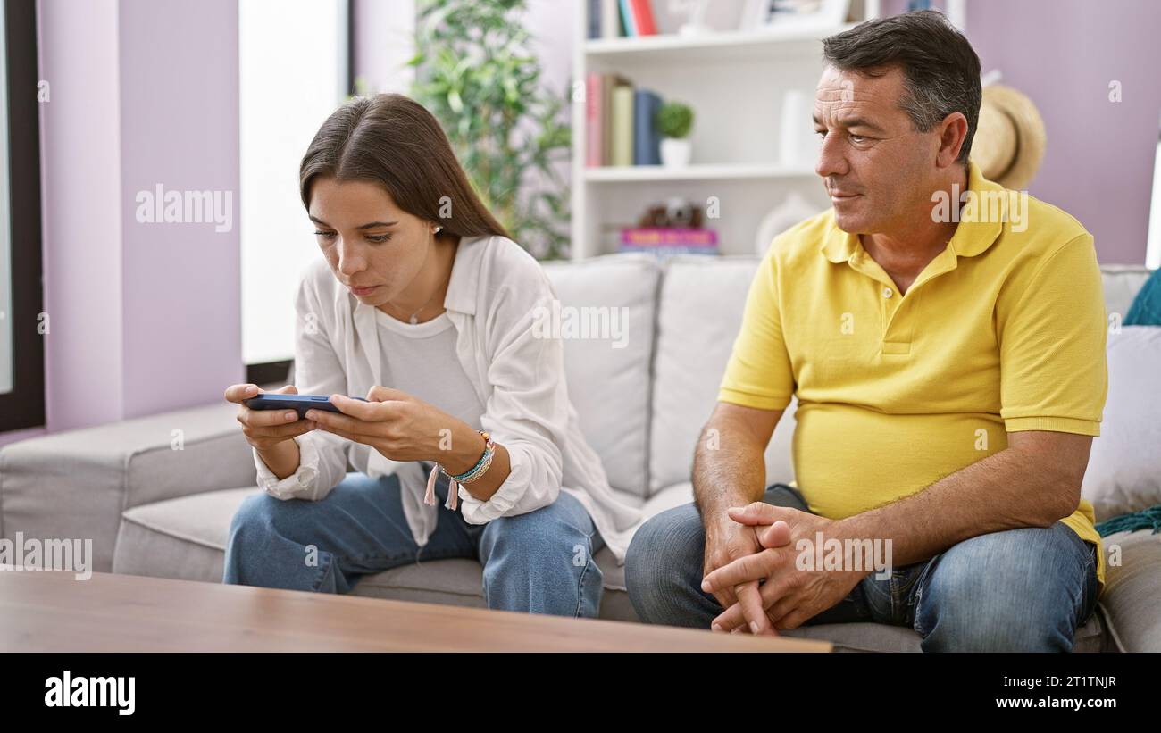 Huddled together at home, father and daughter share a serene indoor ...
