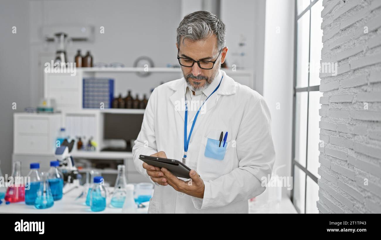 Young hispanic grey-haired man scientist using touchpad at laboratory Stock Photo - Alamy