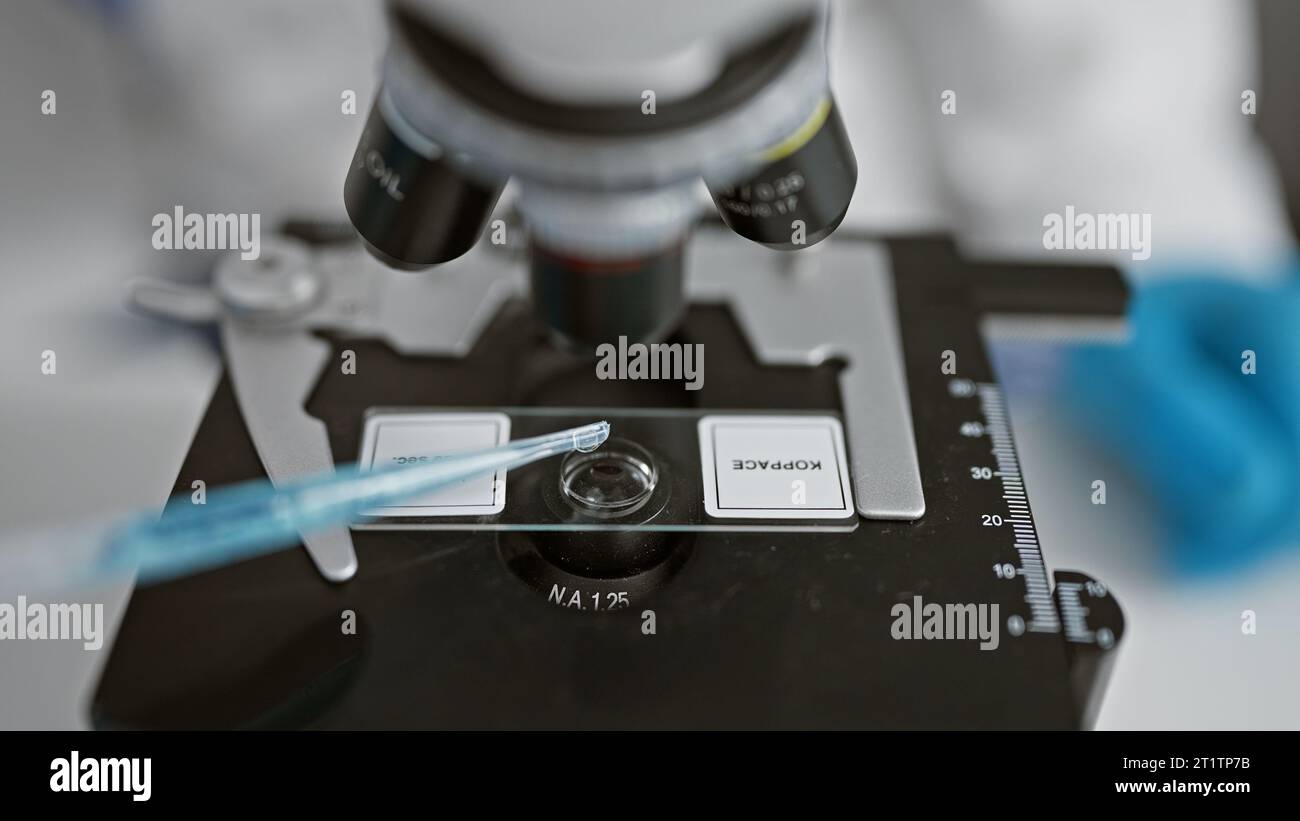 Attractive young hispanic man, grey-haired scientist at work, pouring a ...