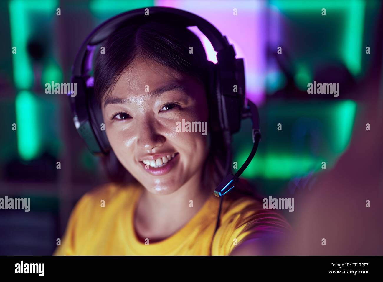 Chinese woman streamer using headset make selfie by camera at gaming ...