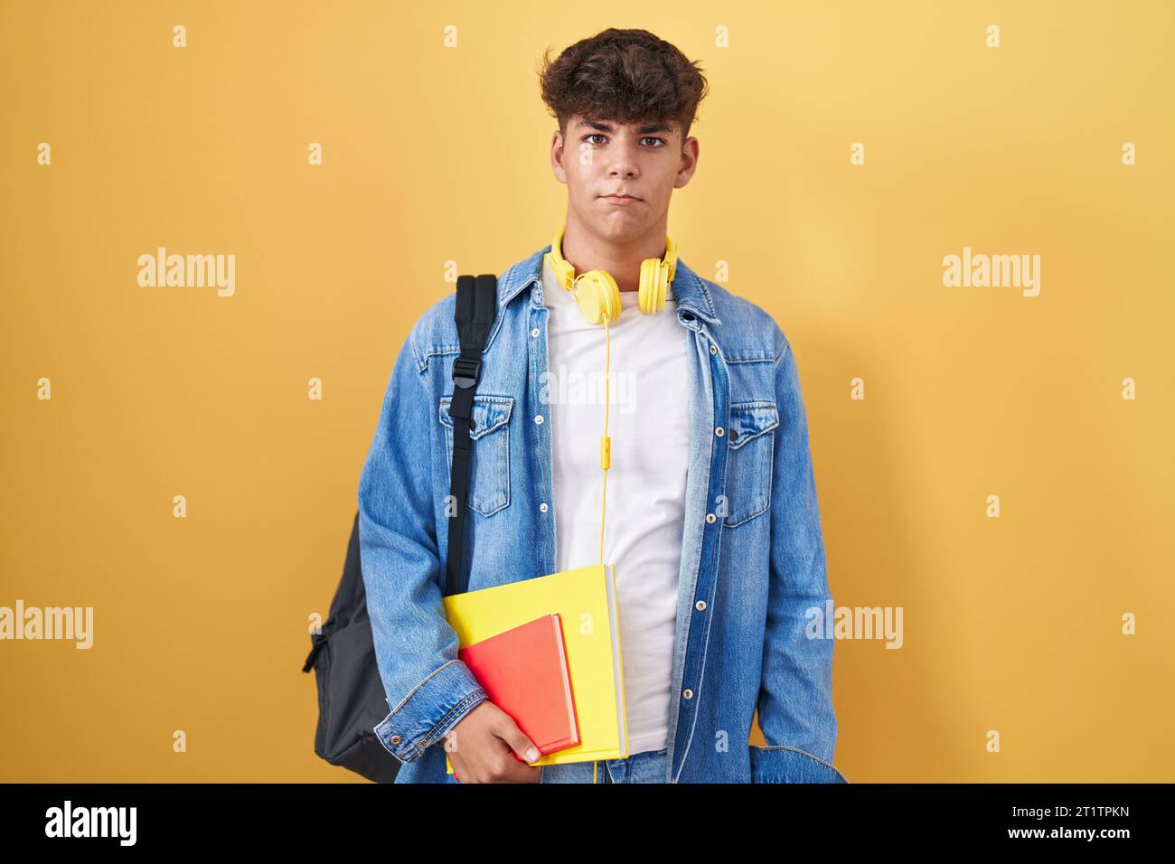 Hispanic teenager wearing student backpack and holding books depressed ...