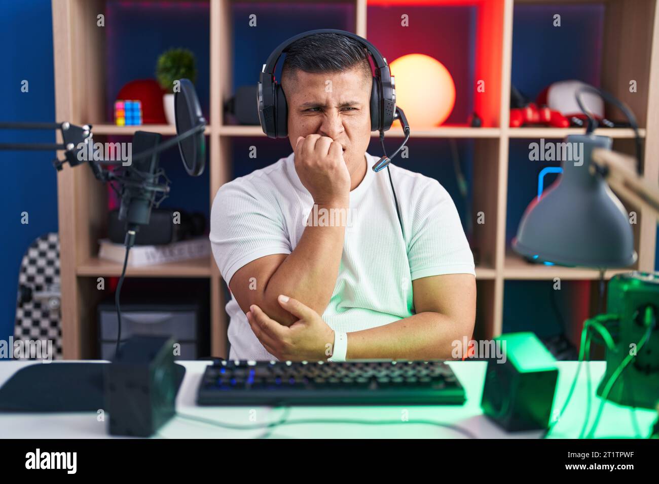 Young hispanic man playing video games looking stressed and nervous ...