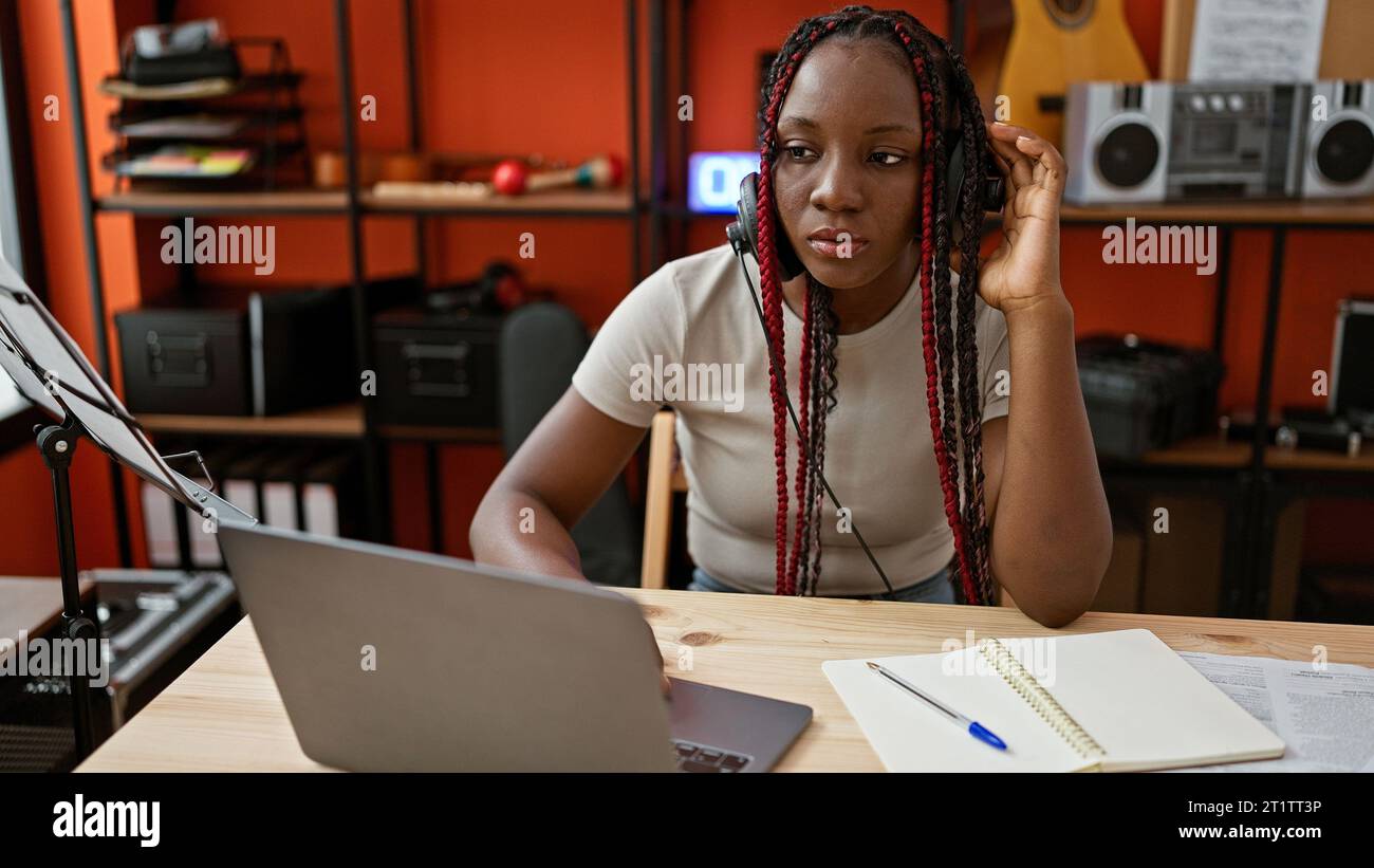 Beautiful african american woman musician sitting at table, mic in hand ...