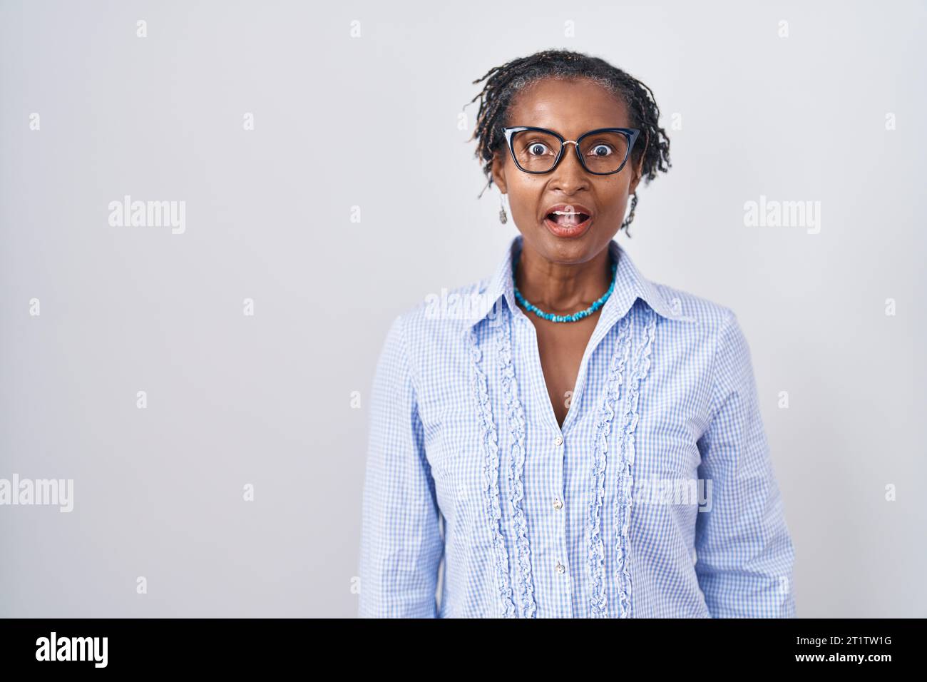 African woman with dreadlocks standing over white background wearing ...