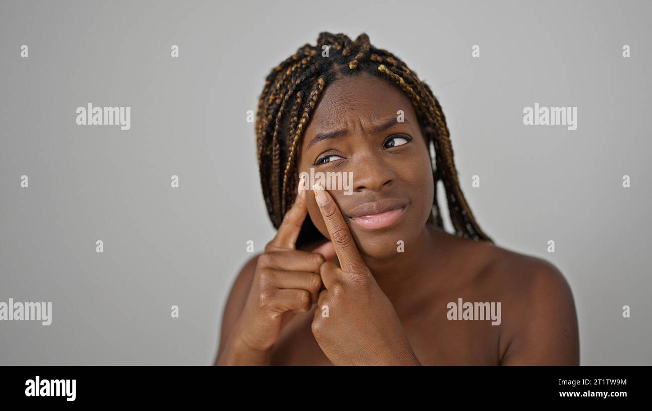 African american woman popping pimple over isolated white background ...