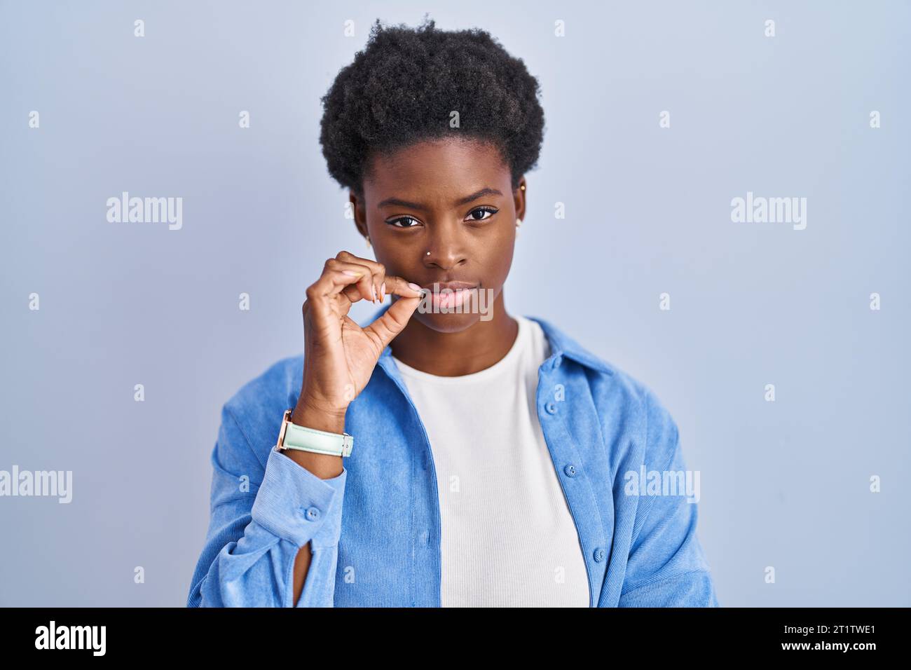 African american woman standing over blue background mouth and lips ...