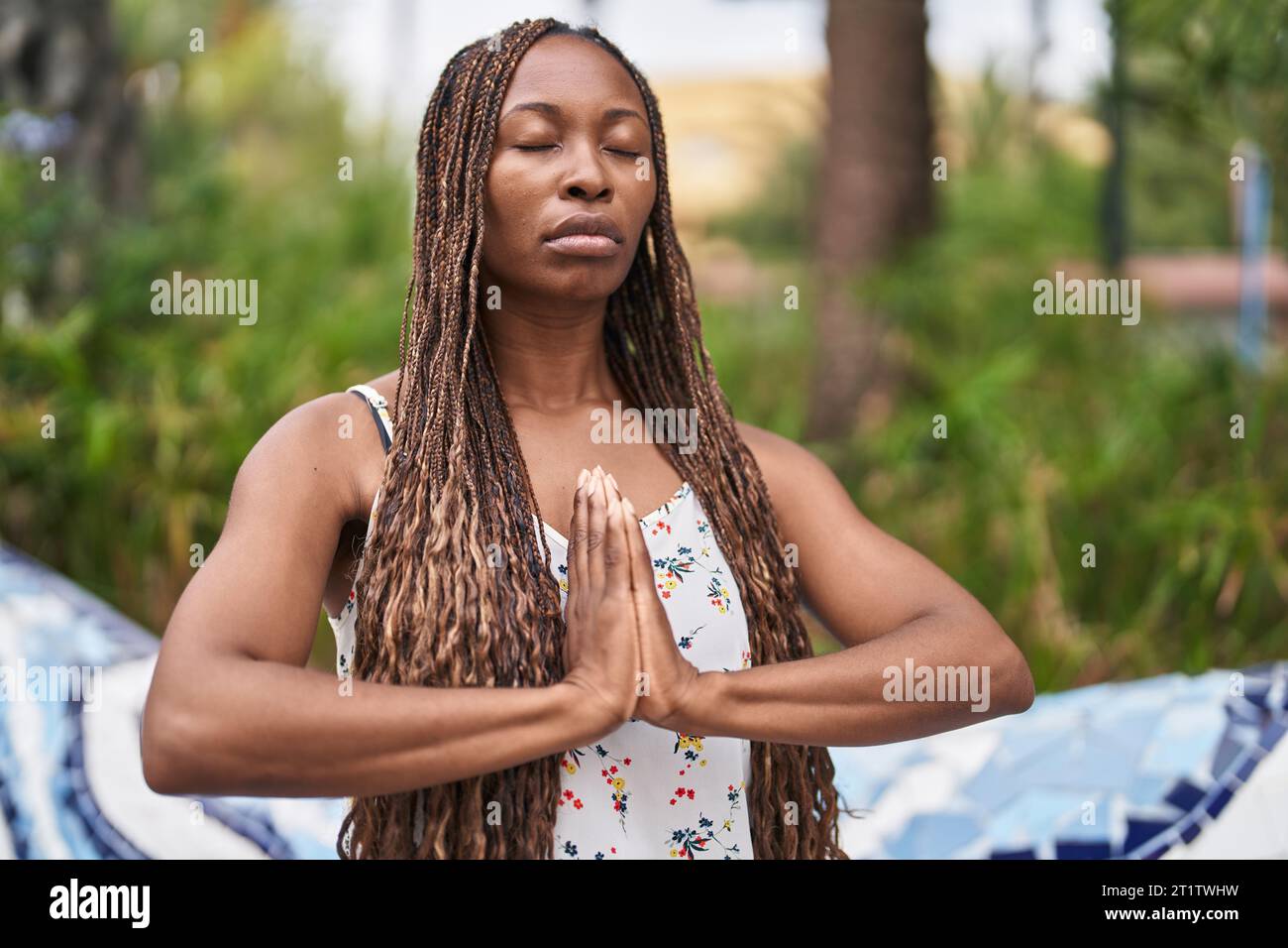 African american woman doing yoga exercise at park Stock Photo - Alamy