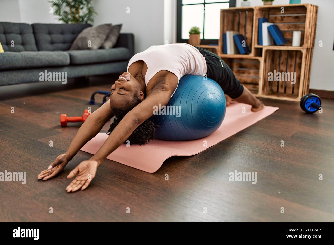 African american woman training abs exercise using fit ball at home ...