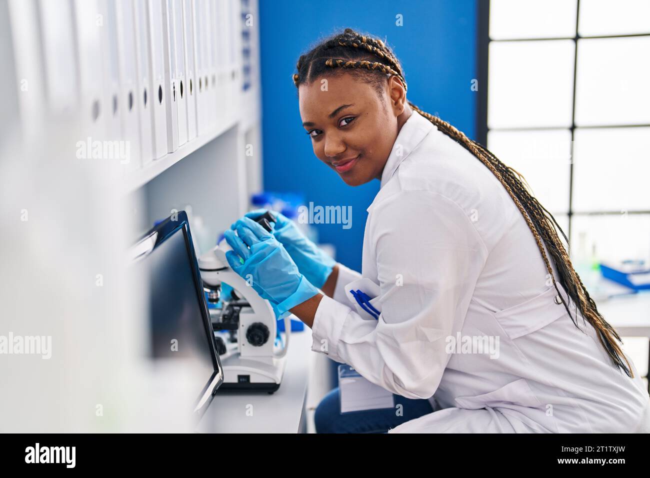 African american woman scientist using microscope at laboratory Stock Photo - Alamy