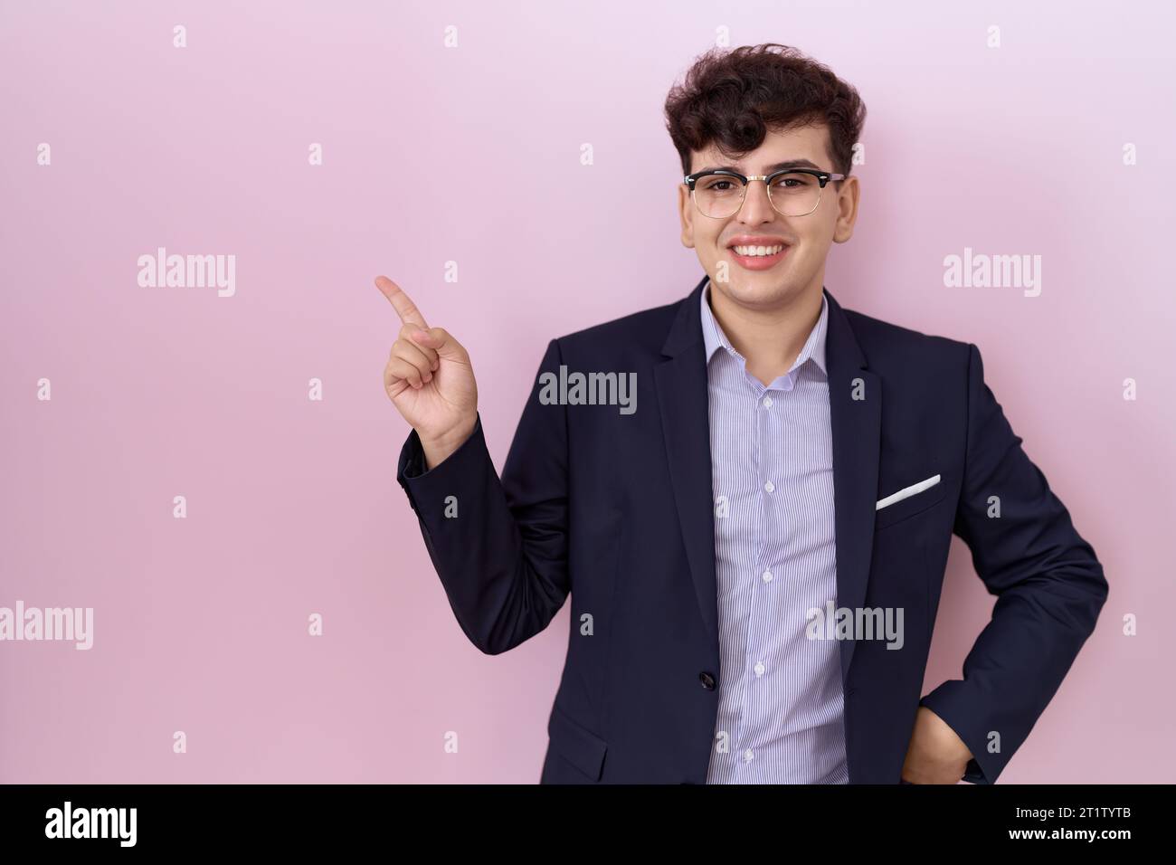 Young non binary man with beard wearing suit and tie with a big smile ...
