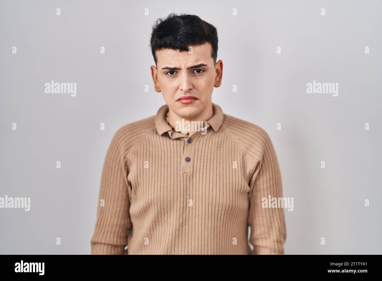 Non binary person standing over isolated background depressed and worry ...