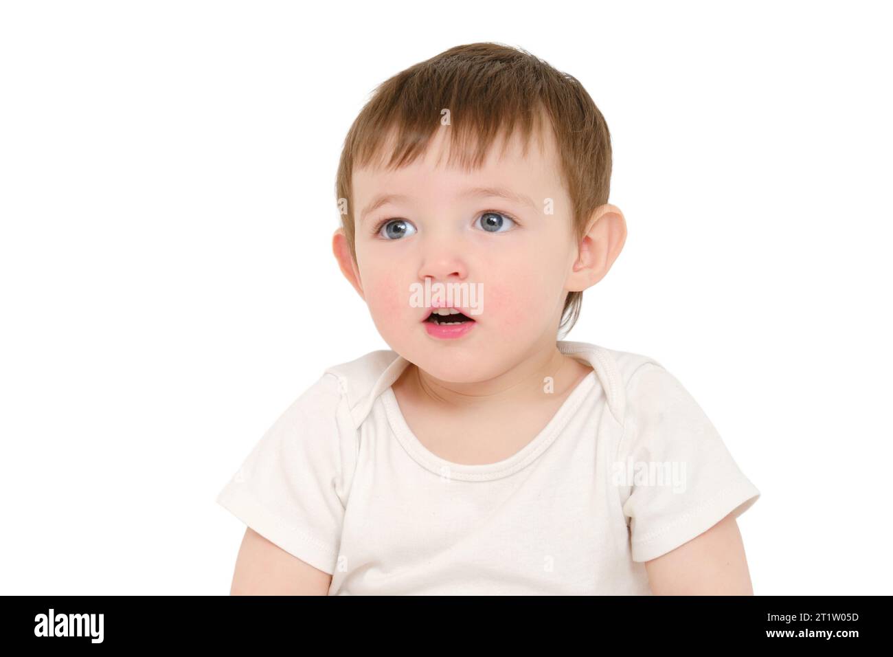 Surprised baby looks up with open mouth, studio, isolated on white ...
