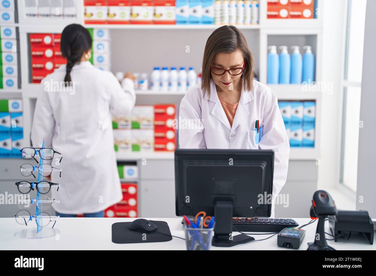 Two women pharmacist using computer working at pharmacy Stock Photo - Alamy