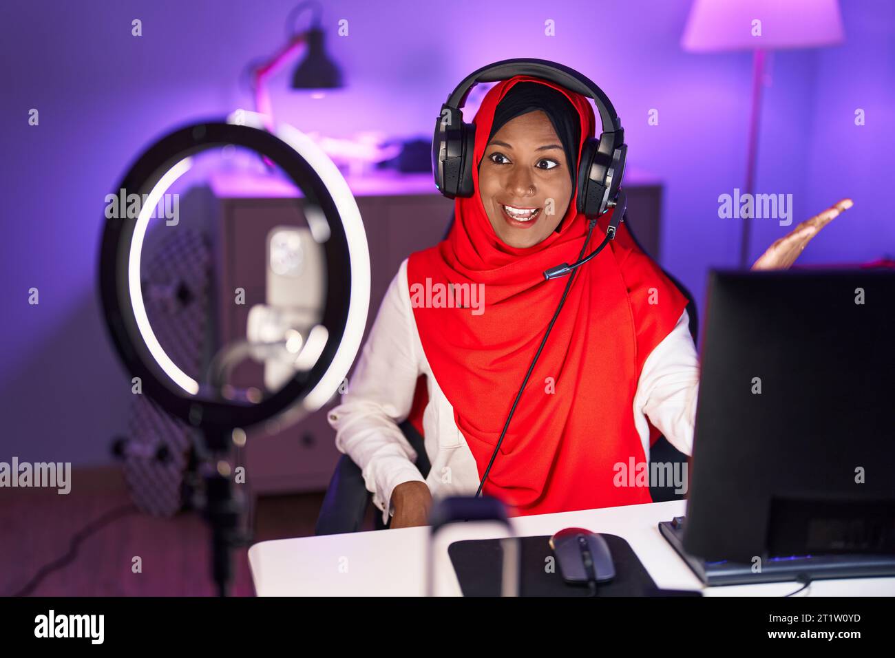 Young indian woman playing video games recording with smartphone ...