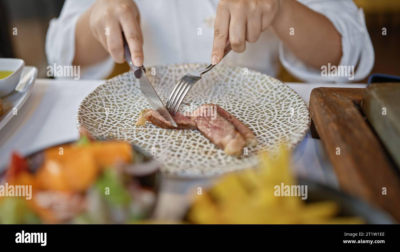 Young woman cutting slice from beef steak at the restaurant Stock Photo ...