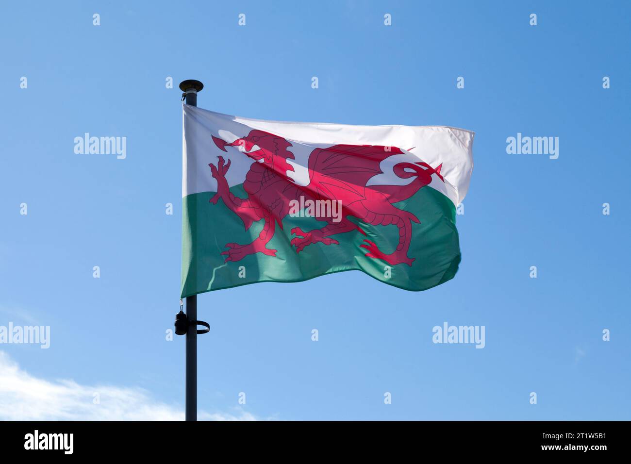 Flag of Wales waving atop of its pole against a blue sky Stock Photo ...