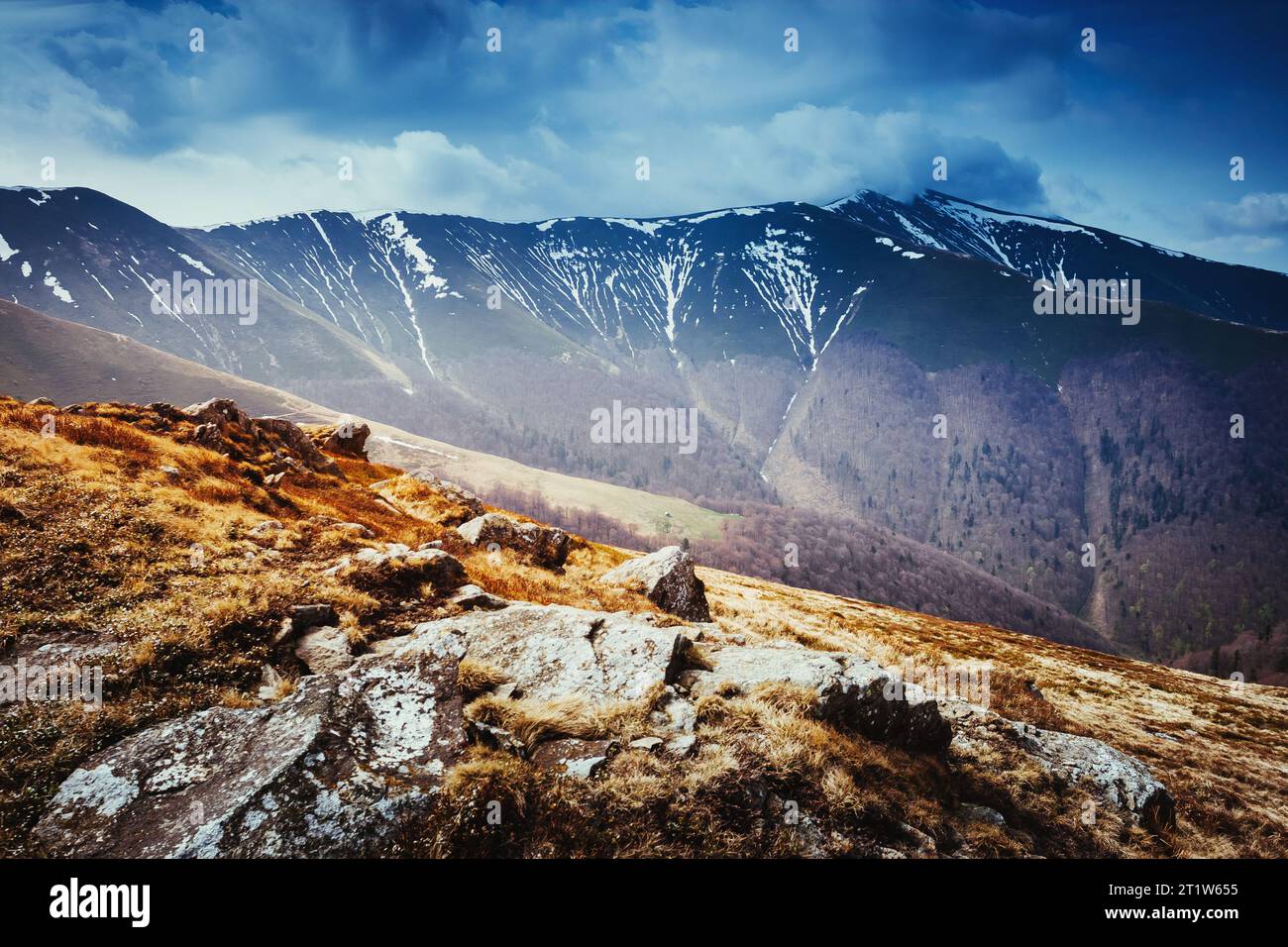 Gloomy view of the snow range under overcast sky. Dramatic scene and ...