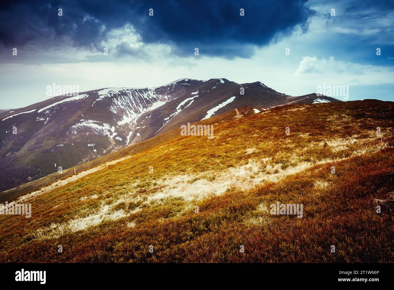 Gloomy view of the snow range under overcast sky. Dramatic scene and ...