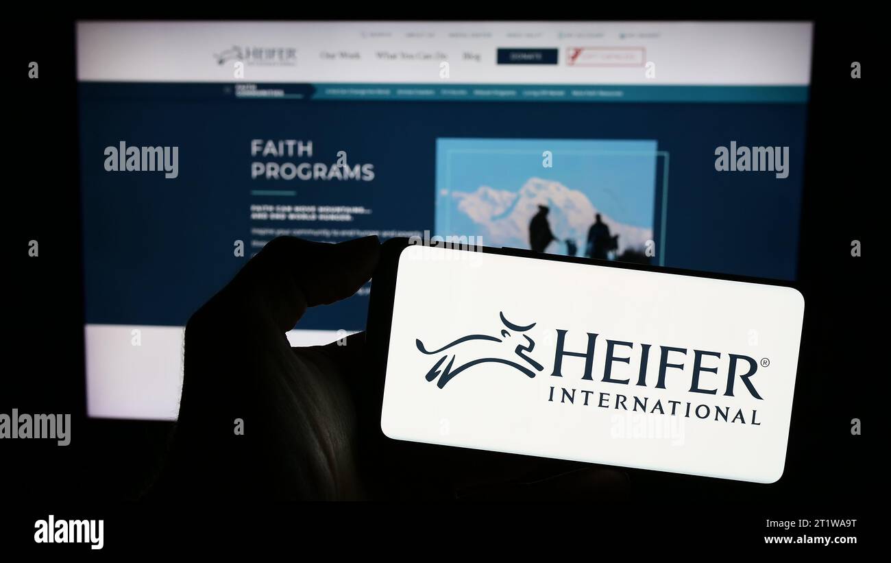 Person holding mobile phone with logo of development organization ...