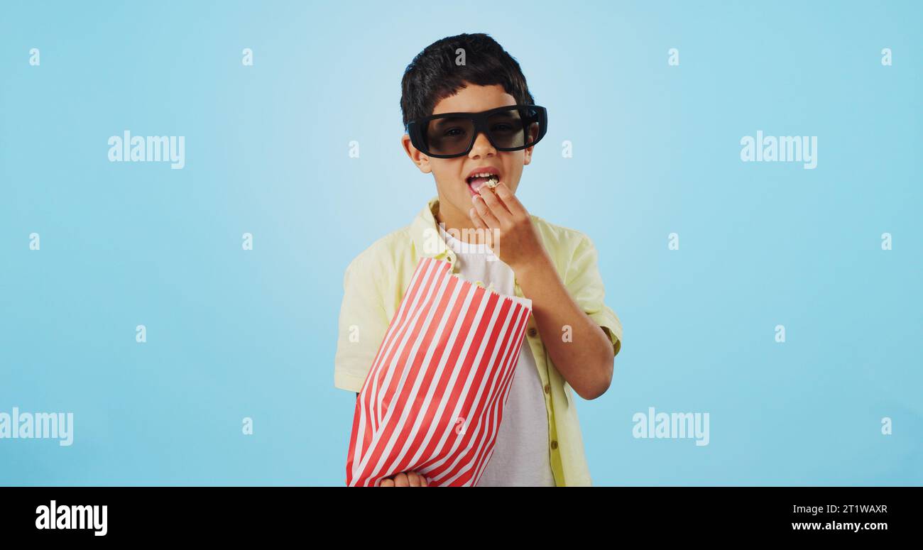 Popcorn, 3d or child in studio for a movie, watching tv or VR film on ...