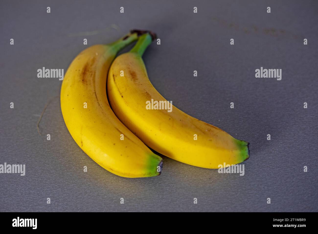 two bananas on a gray background Stock Photo - Alamy