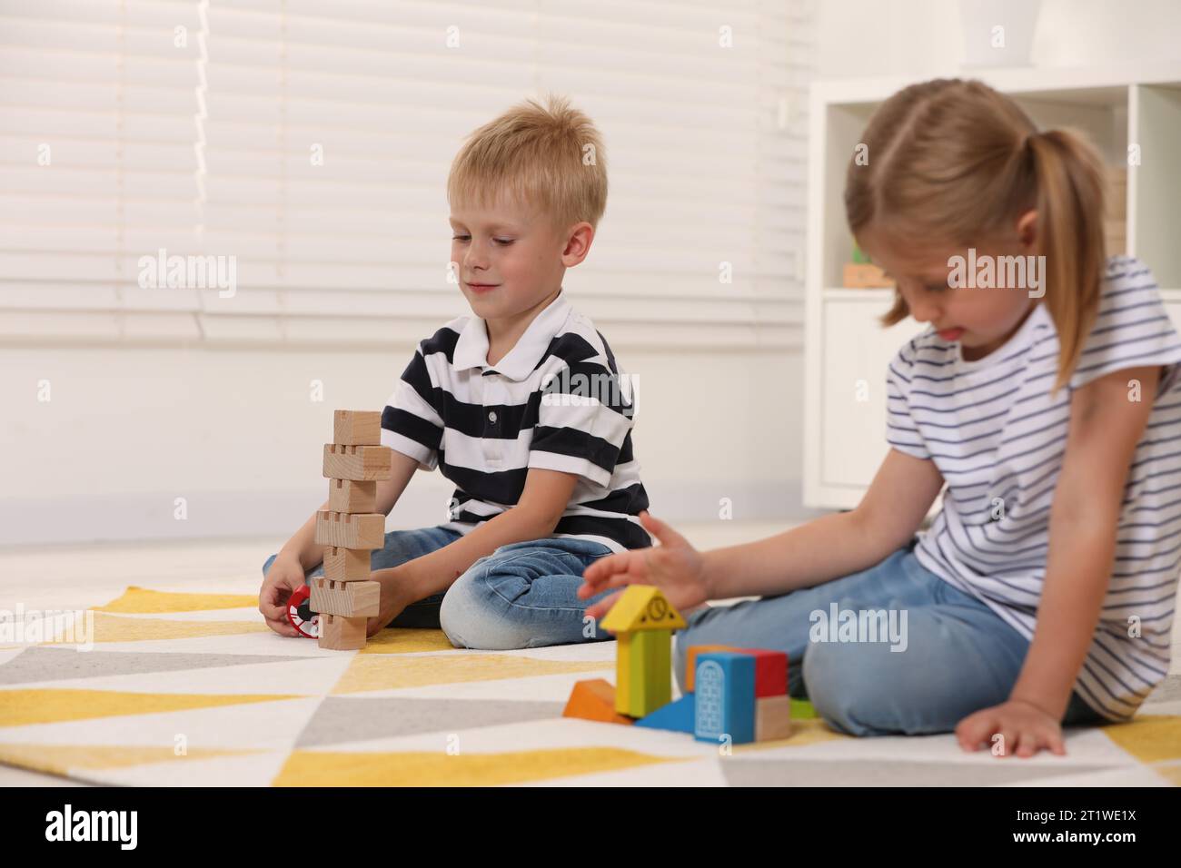 Little children playing with building blocks indoors. Wooden toys Stock ...