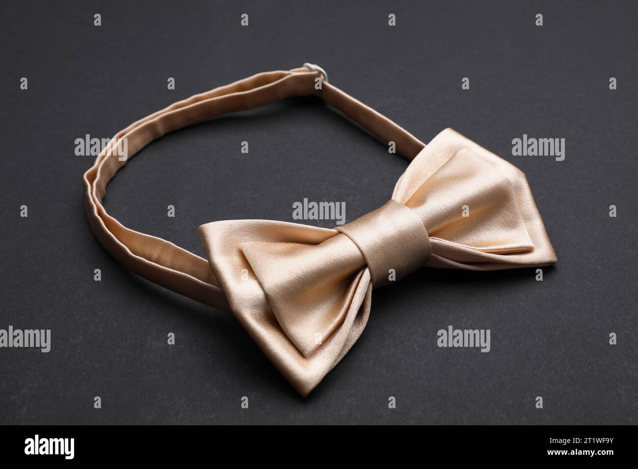 Stylish beige bow tie on black background Stock Photo - Alamy