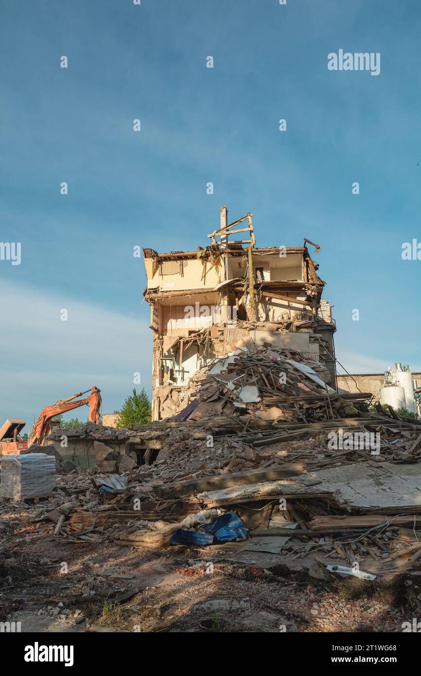 Demolition of ruined building. Excavator breaks old house damaged by ...