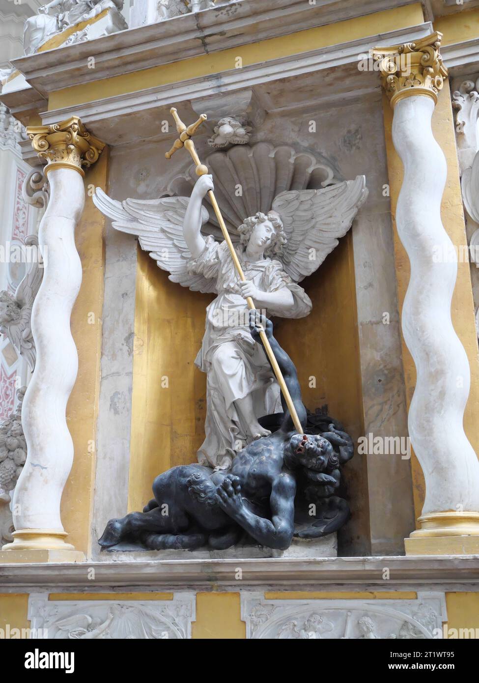 Statue of St. Michael as archangel pushing devil down to earth in ...