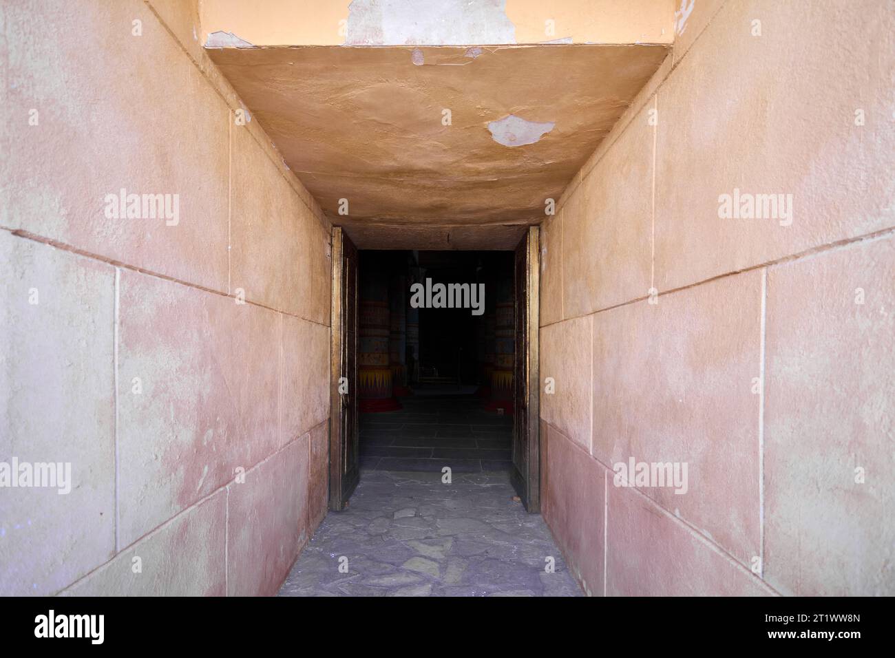 Narrow hallway with a low ceiling that leads to the entrance to a ...