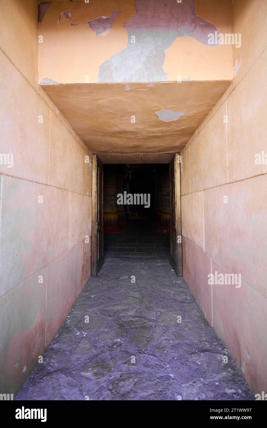 Narrow hallway with a low ceiling that leads to the entrance to a ...