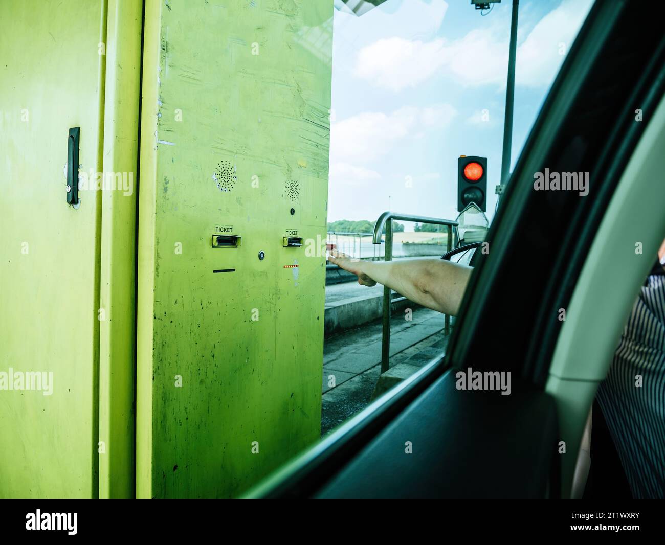 Woman's hand grasping a toll ticket from a French peage machine ...