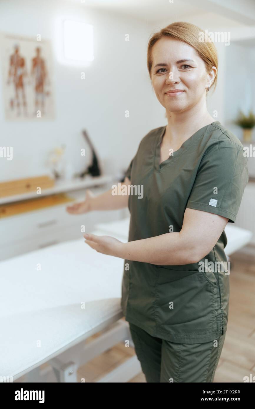 Healthcare time. happy female medical massage therapist in massage cabinet welcoming Stock Photo ...