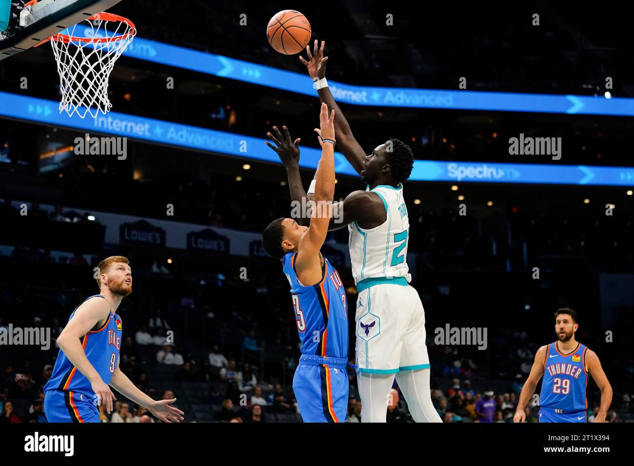 Charlotte Hornets forward JT Thor, right, takes a shot over Oklahoma City Thunder guard Tre Mann ...