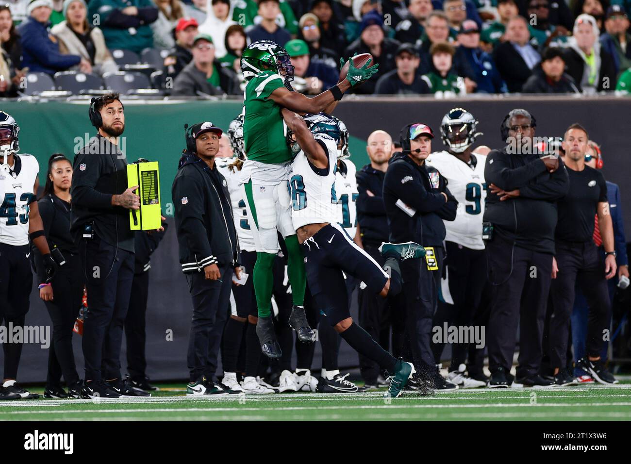New York Jets' Garrett Wilson, left, makes a catch over Philadelphia ...
