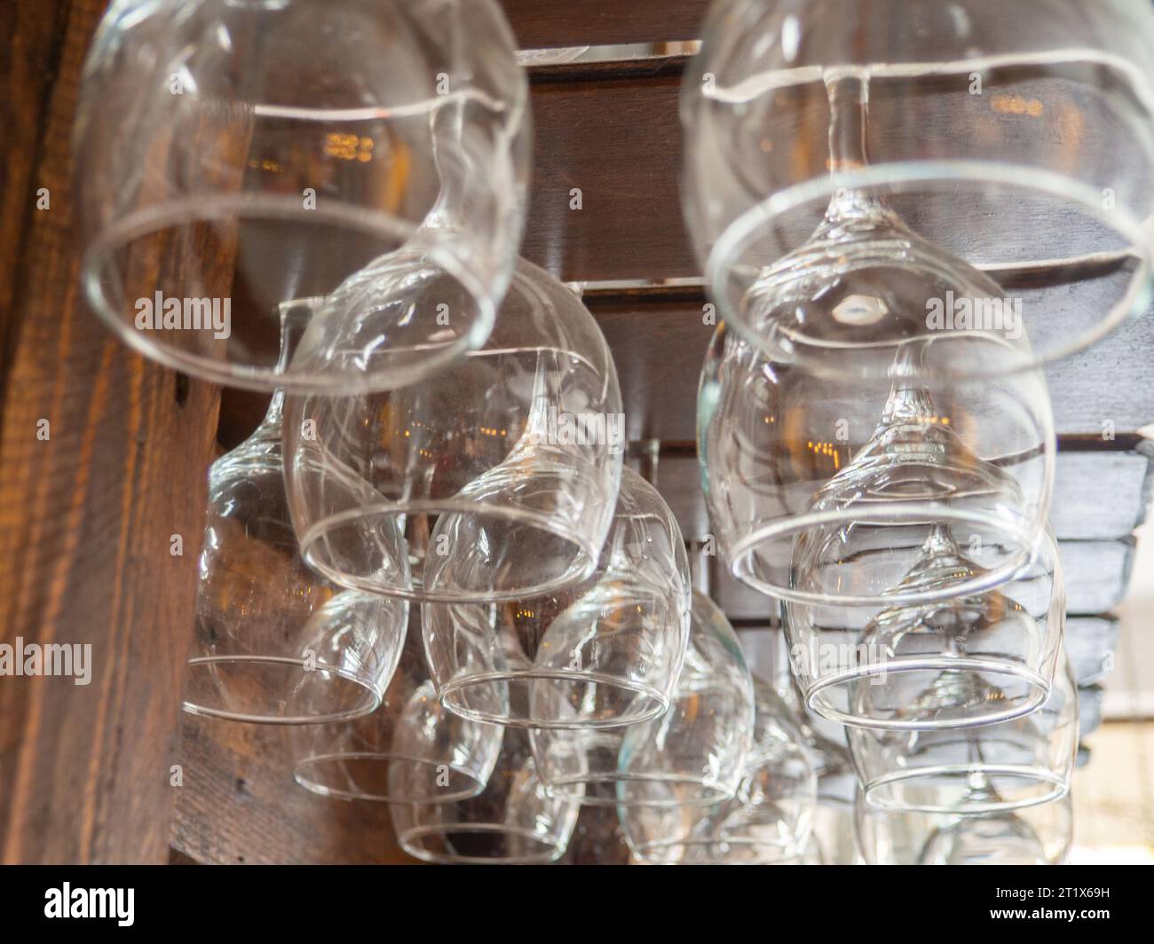 Glasses hang over the bar counter. The glasses are turned upside down ...