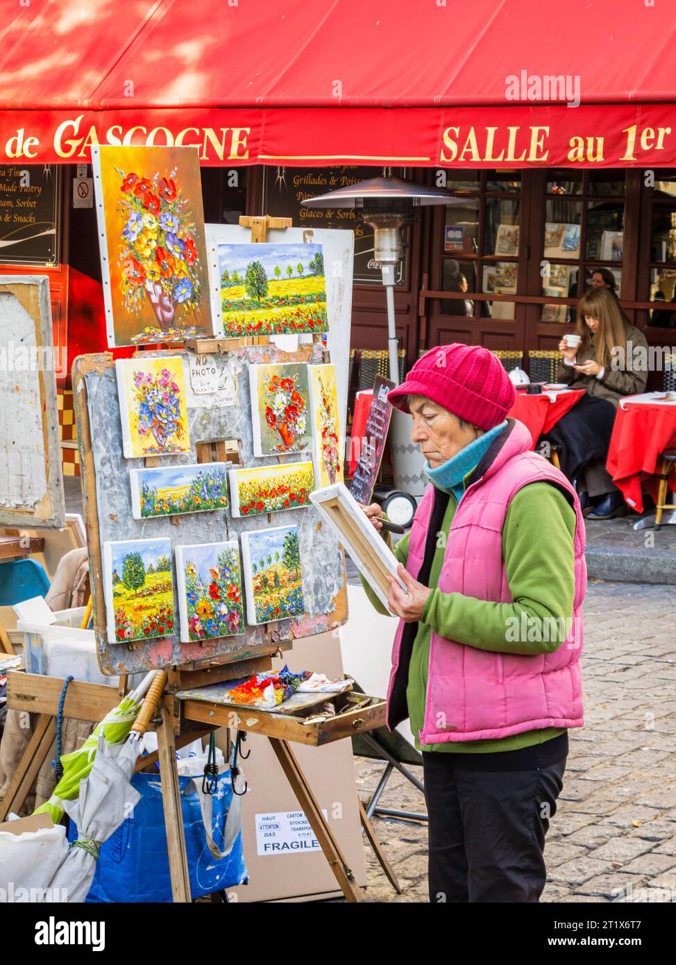 Painter and display of the artist's works of colourful paintings of ...