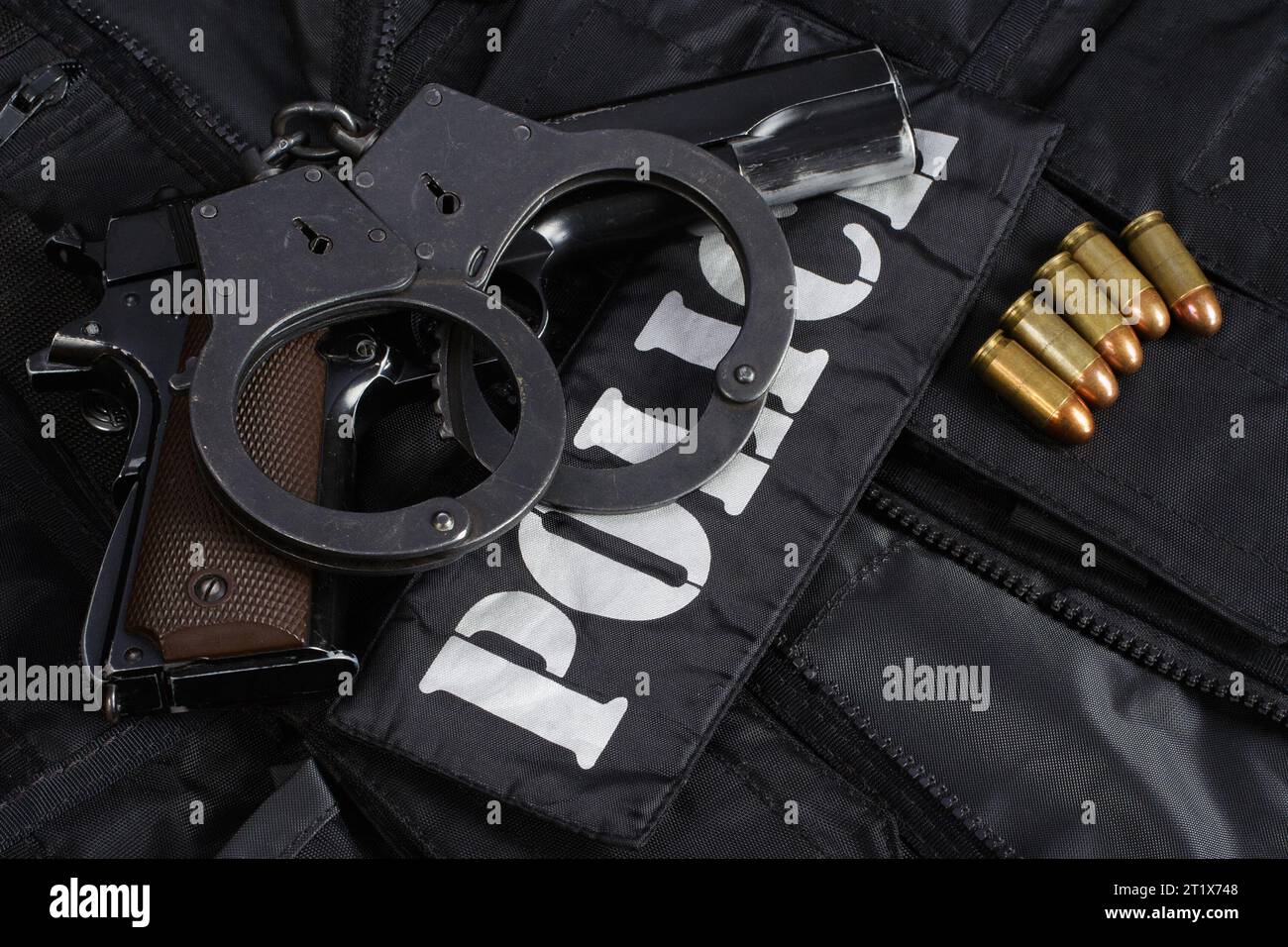 Police handgun with handcuffs on black uniform background Stock Photo ...