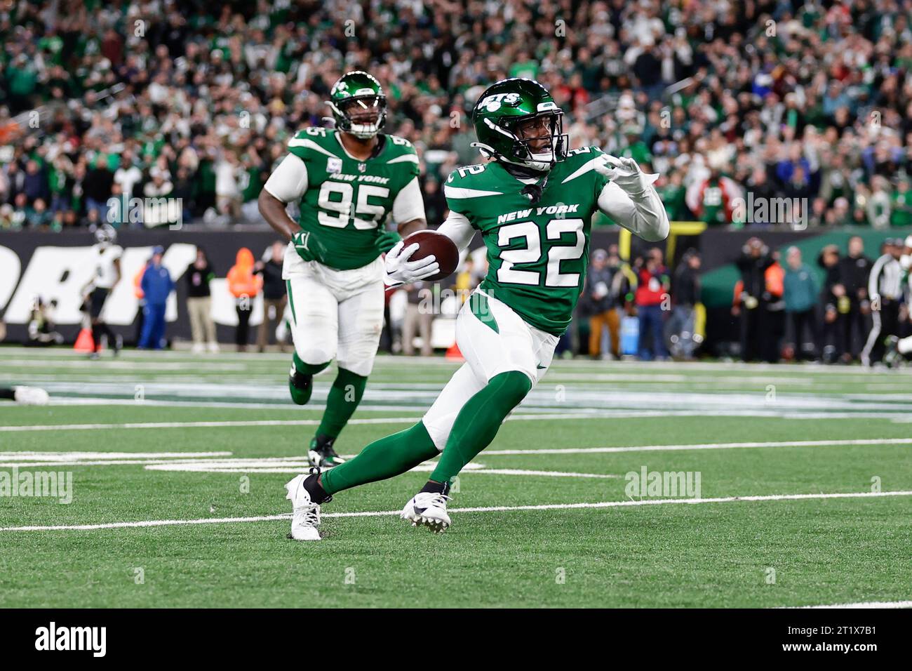 New York Jets' Tony Adams, right, runs with the ball after an ...