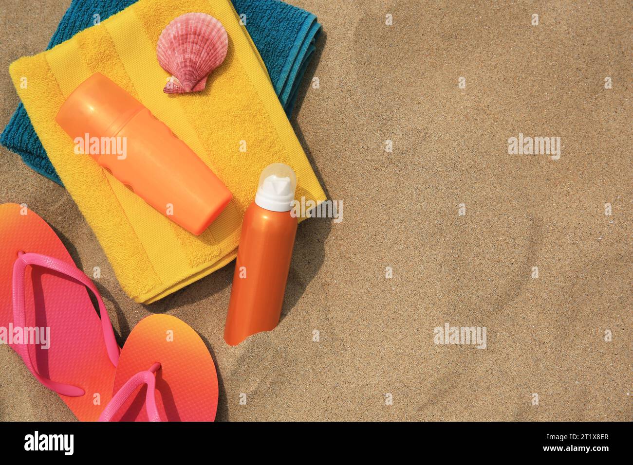 Flat lay composition with sunscreens on sand, space for text. Sun ...