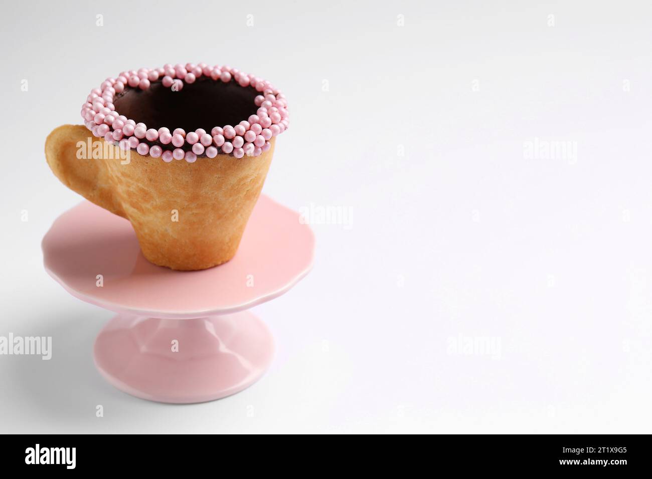 Delicious edible biscuit cup decorated with sprinkles on white ...