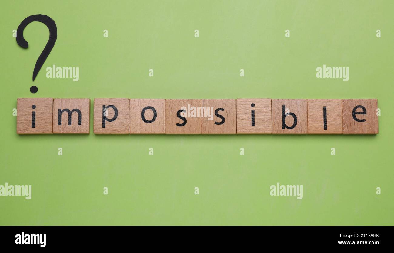 Motivation concept. Word Impossible and question mark on light green ...