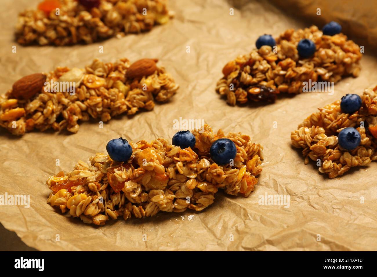 Different granola bars on parchment paper, closeup. Healthy snack Stock ...