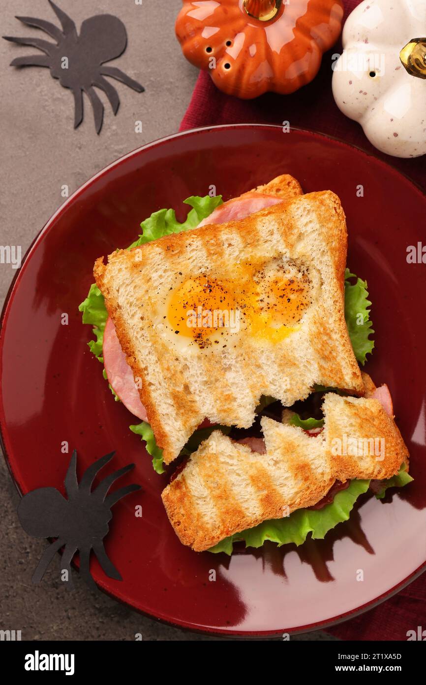 Cute monster sandwich with fried eggs on grey textured table, flat lay ...