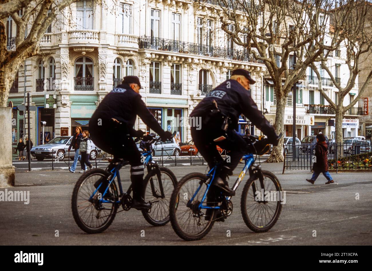 French police officers cycle across a town square in the city of ...