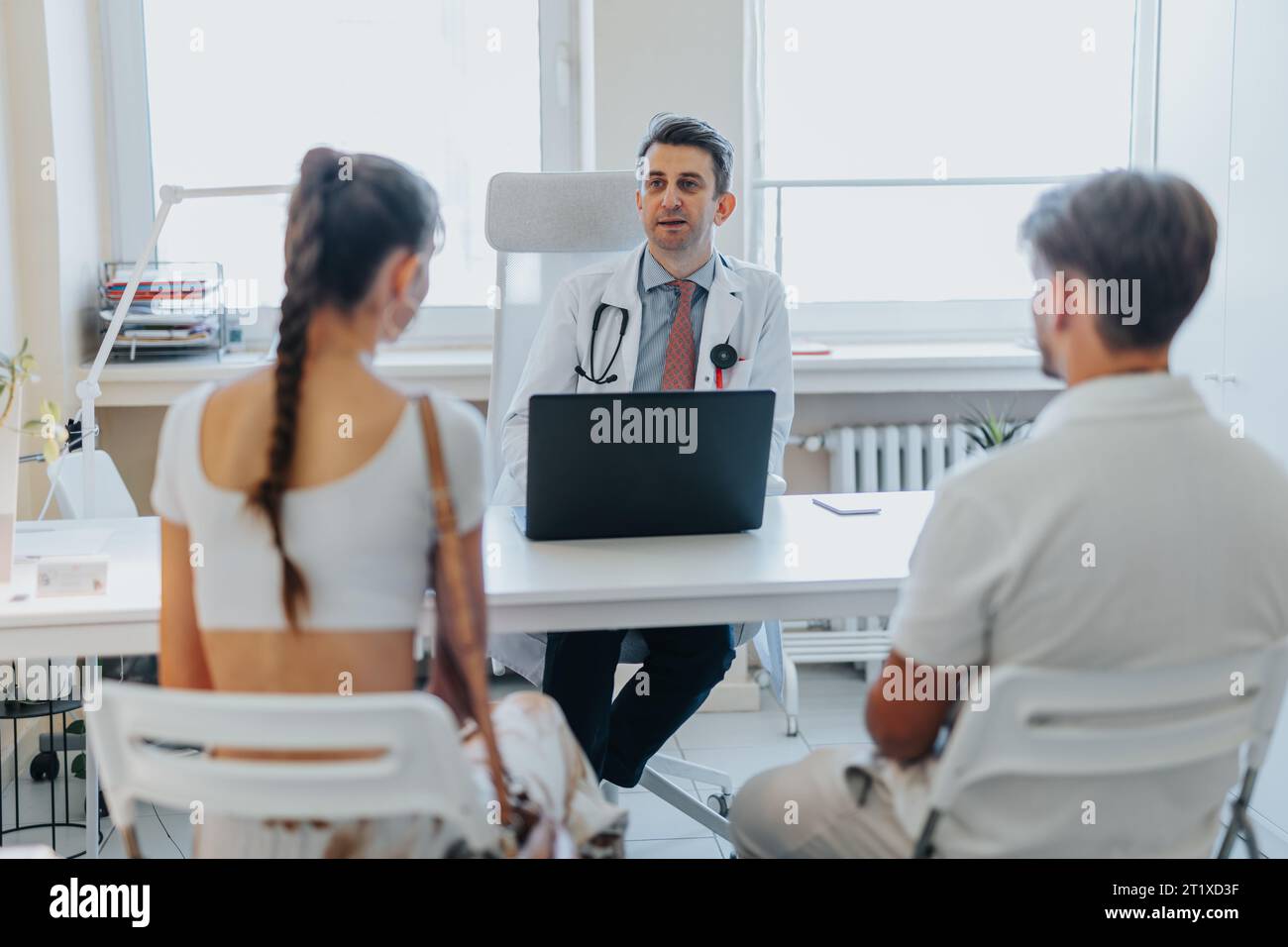 Group of doctors advising a couple in a clinic. Discussion about ...