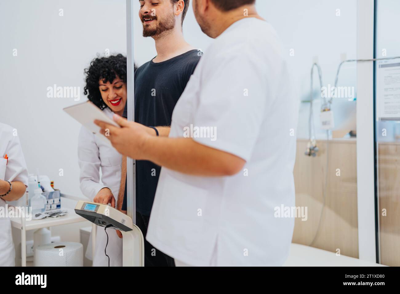 Experienced doctor measuring height of young patient with stadiometer ...