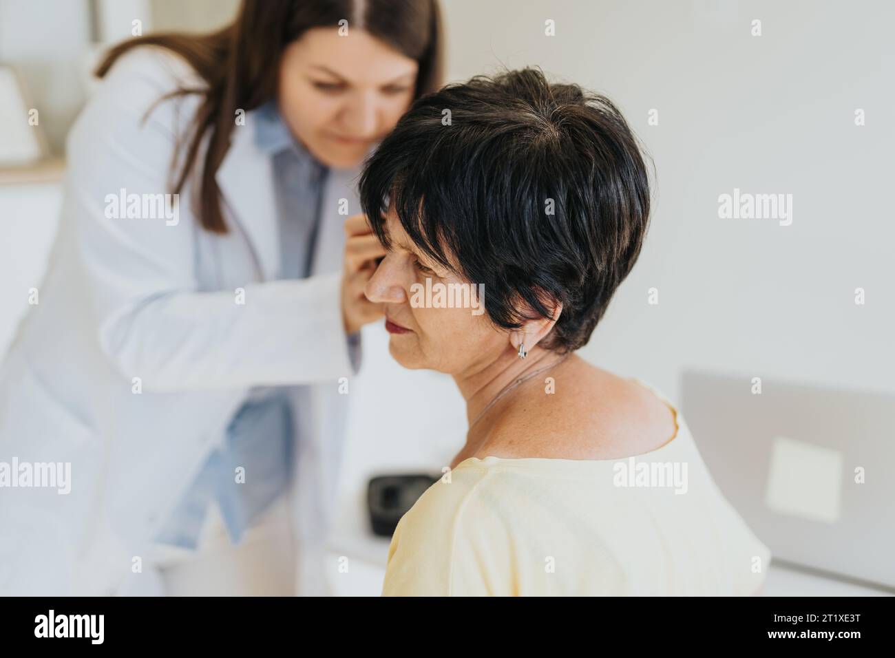 Experienced doctor checking her elderly patient hearing. Older female ...