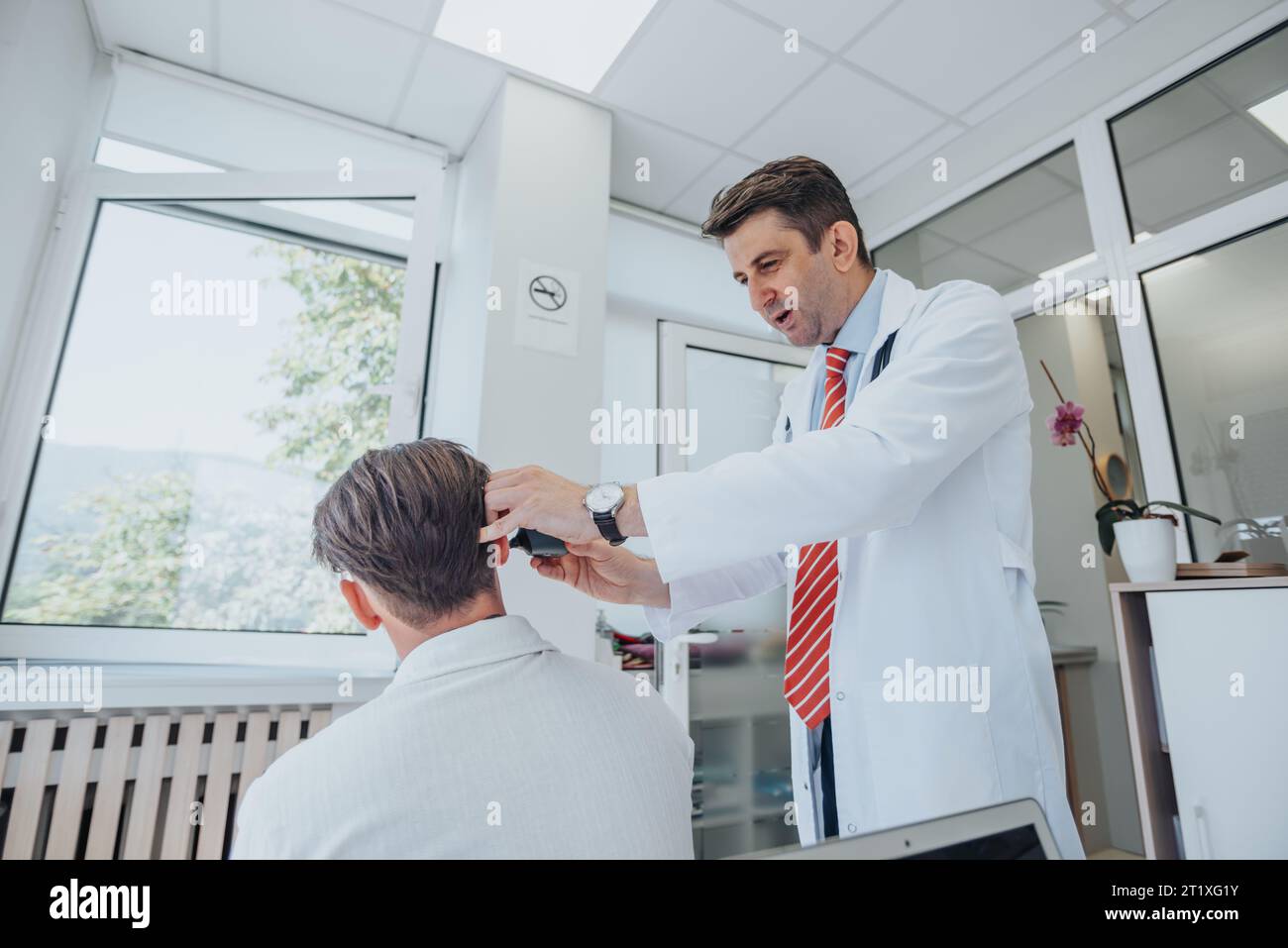 Experienced doctors in clinic examining patients ears. Using video ...